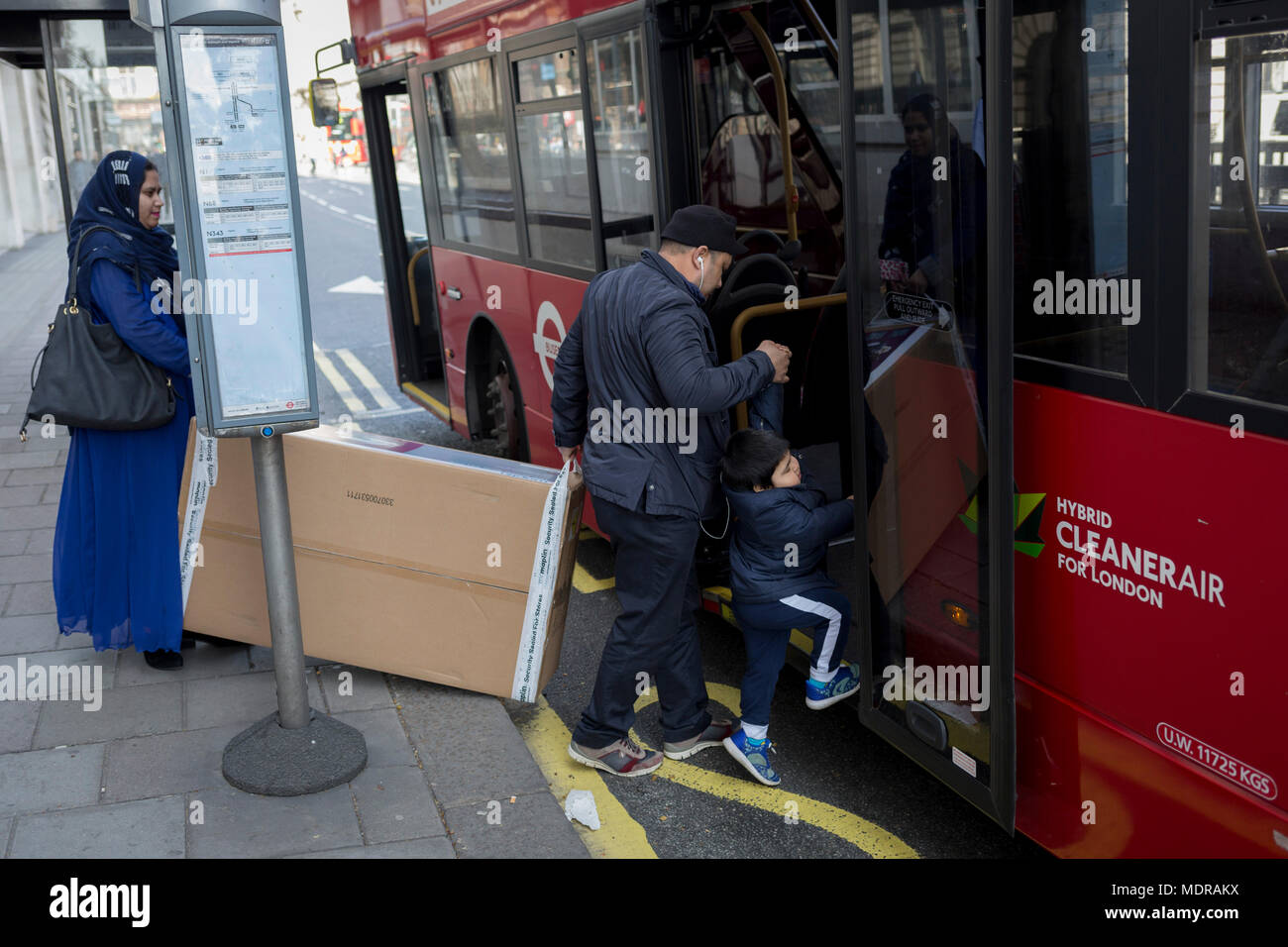 A family load a large box on to a London bus in Aldwych in centrlal ...