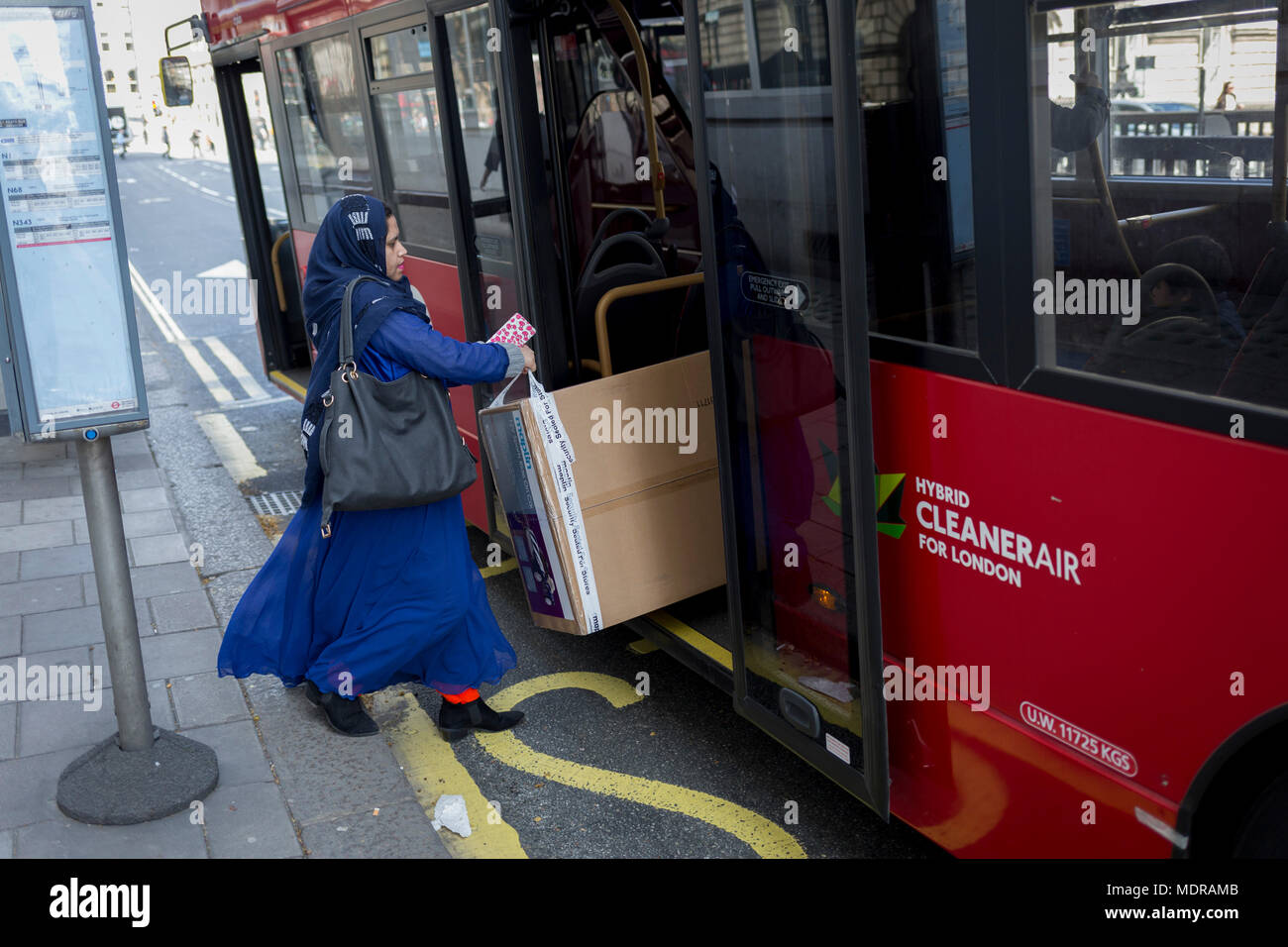 A family load a large box on to a London bus in Aldwych in centrlal ...