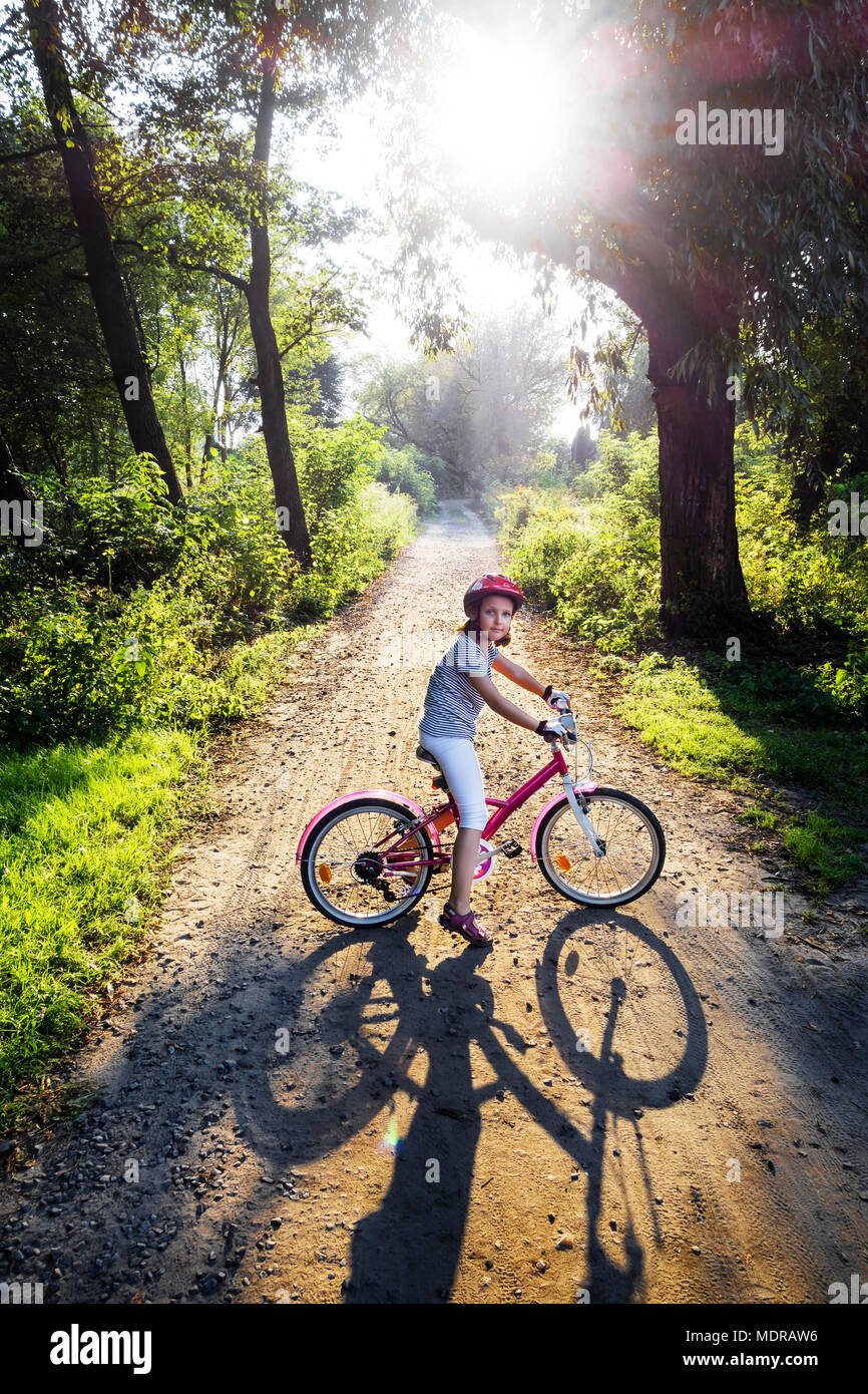 Girl on a bicycle in summer park outdoors, sunset Stock Photo - Alamy