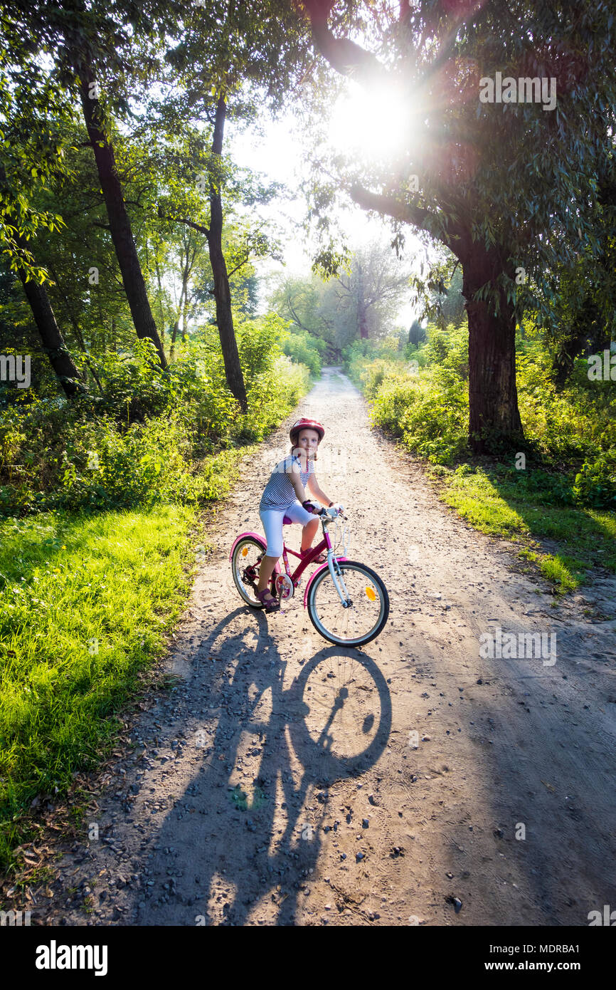 Girl on a bicycle in summer park outdoors, sunset Stock Photo - Alamy