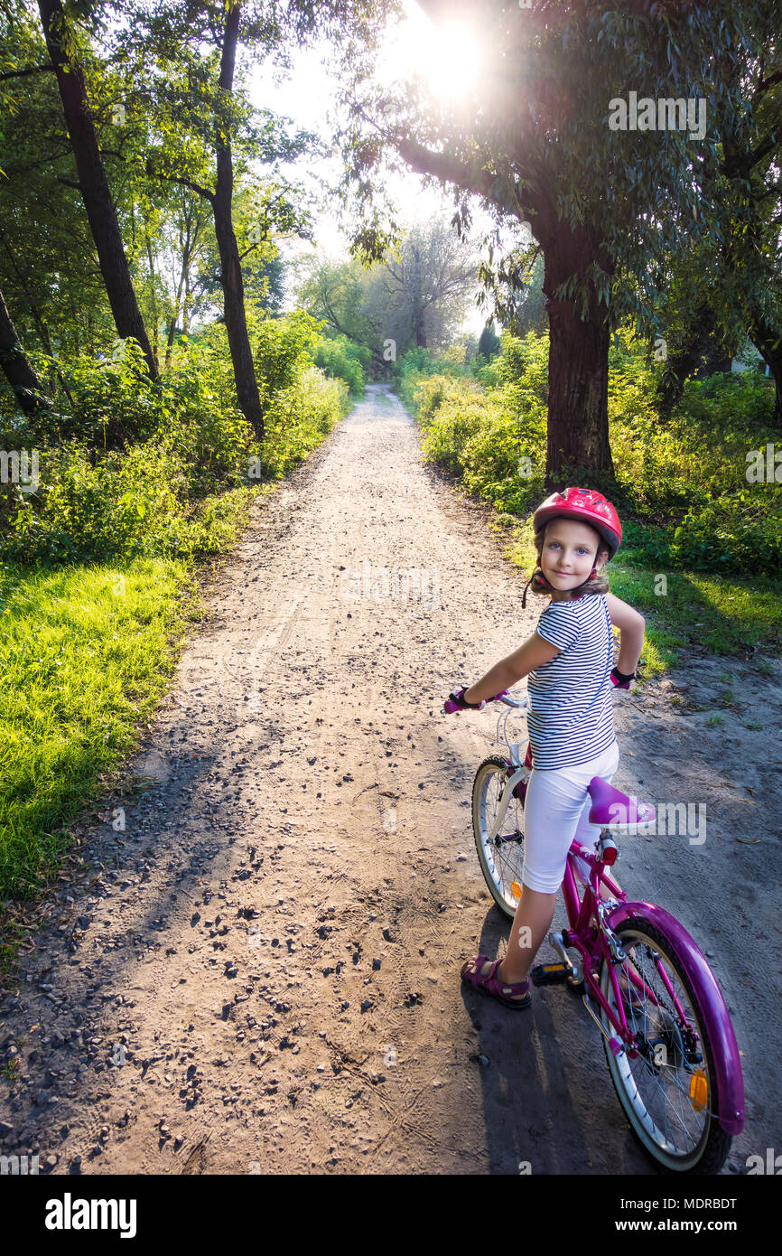 Girl on a bicycle in summer park outdoors, sunset Stock Photo - Alamy