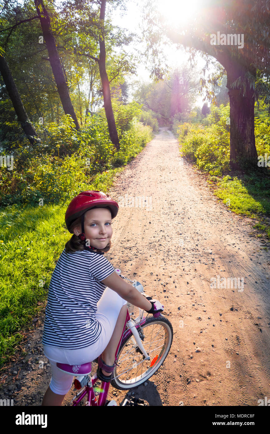 Girl on a bicycle in summer park outdoors, sunset Stock Photo - Alamy