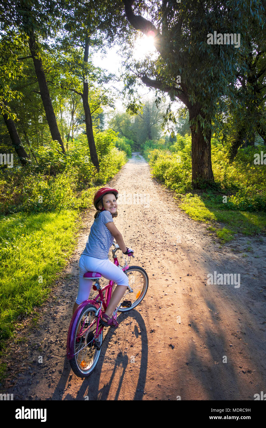 Girl on a bicycle in summer park outdoors, sunset Stock Photo - Alamy