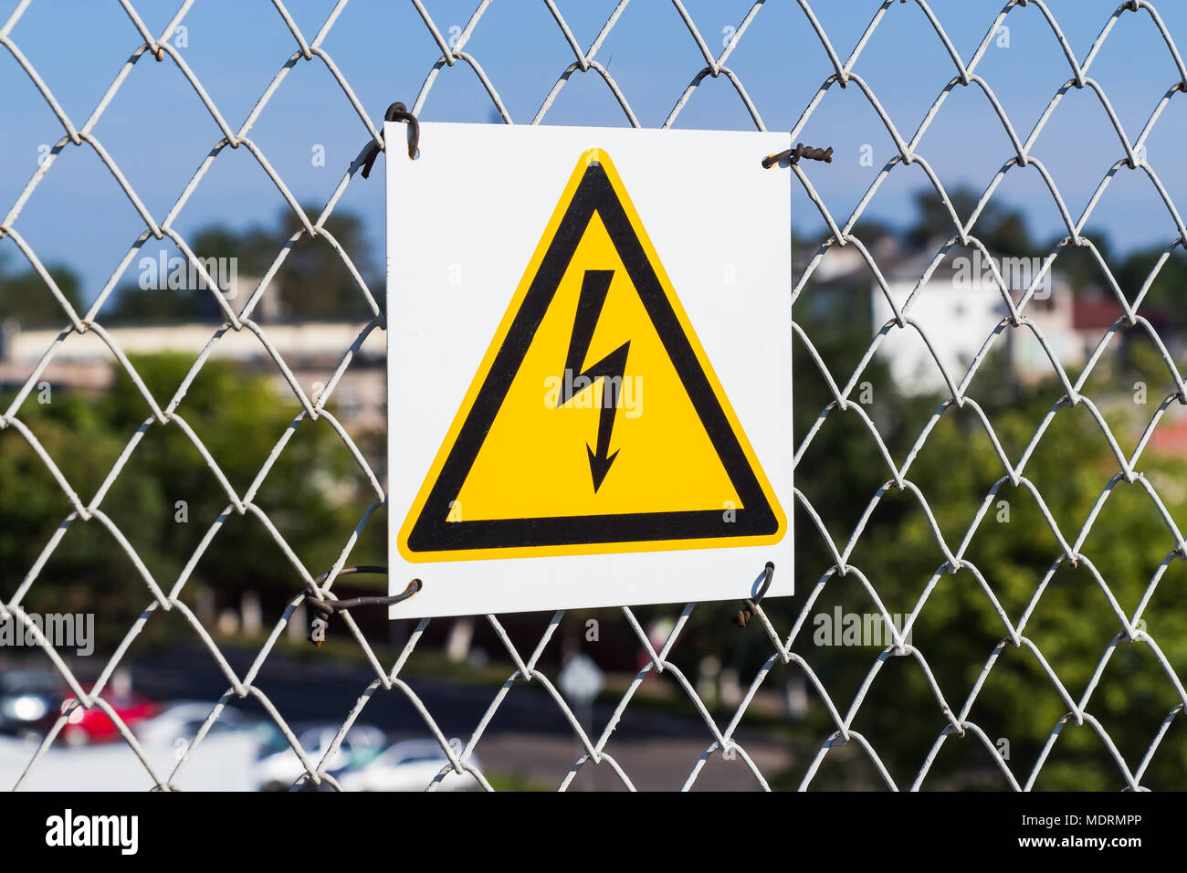 Yellow high voltage sign hanging on the metal mesh Stock Photo - Alamy