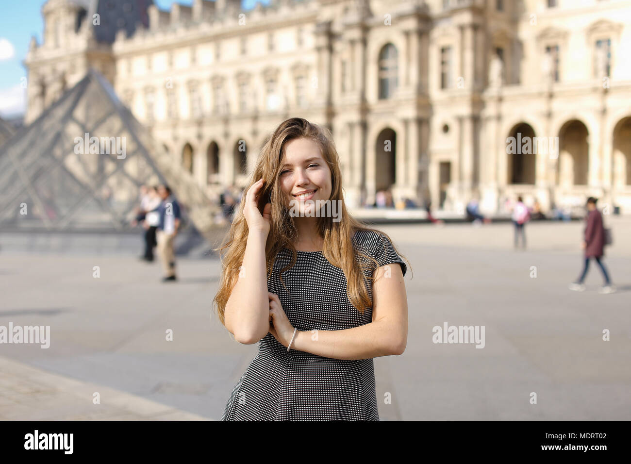Young girl standing near Louvre Pyramid and smiling Stock Photo - Alamy
