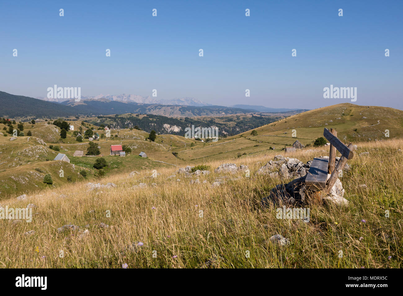 Bench in a hilly landscape with houses in Durmitor National Park in ...