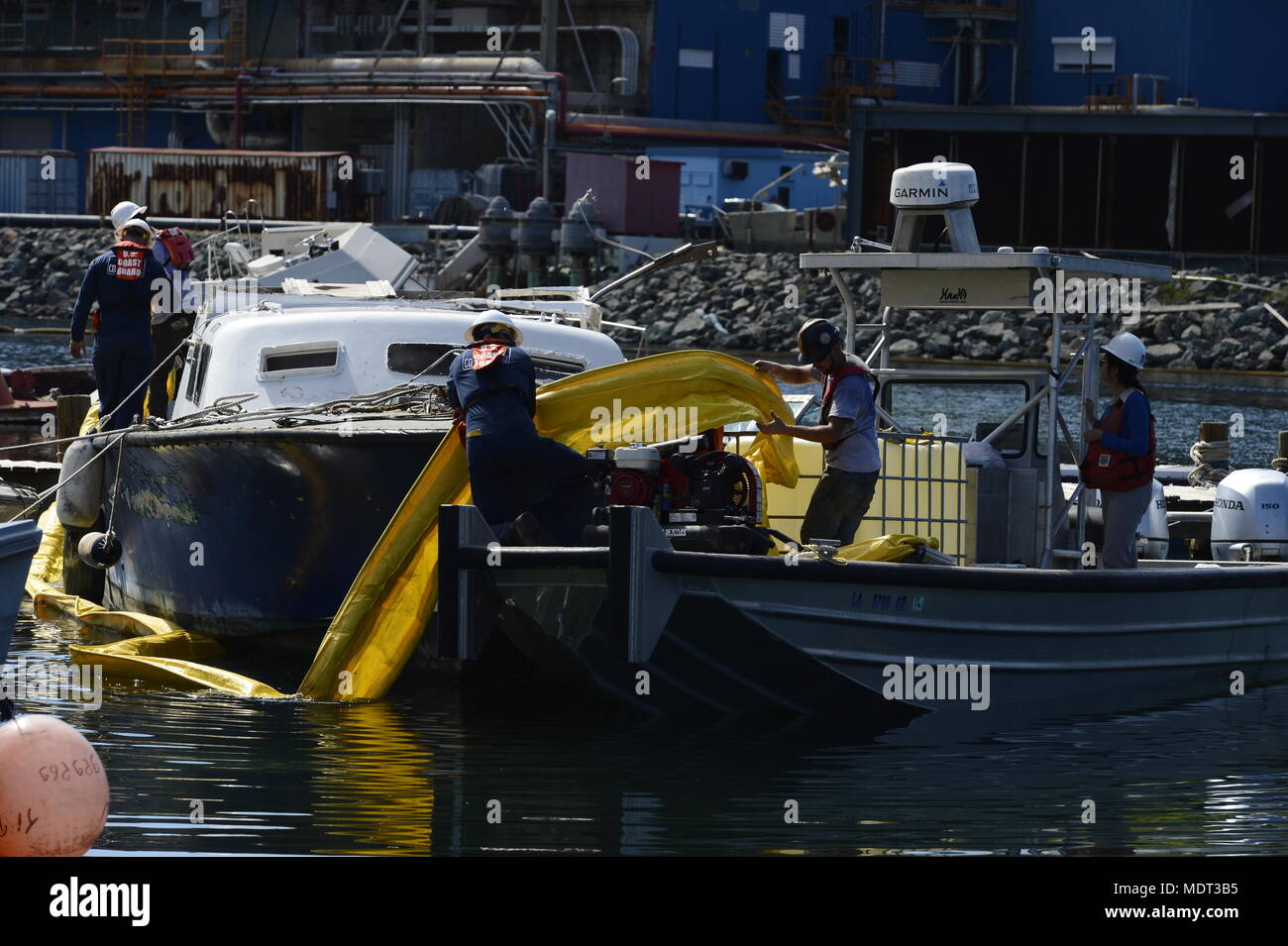 Coast Guard members and a contractor with the Environmental Protection ...