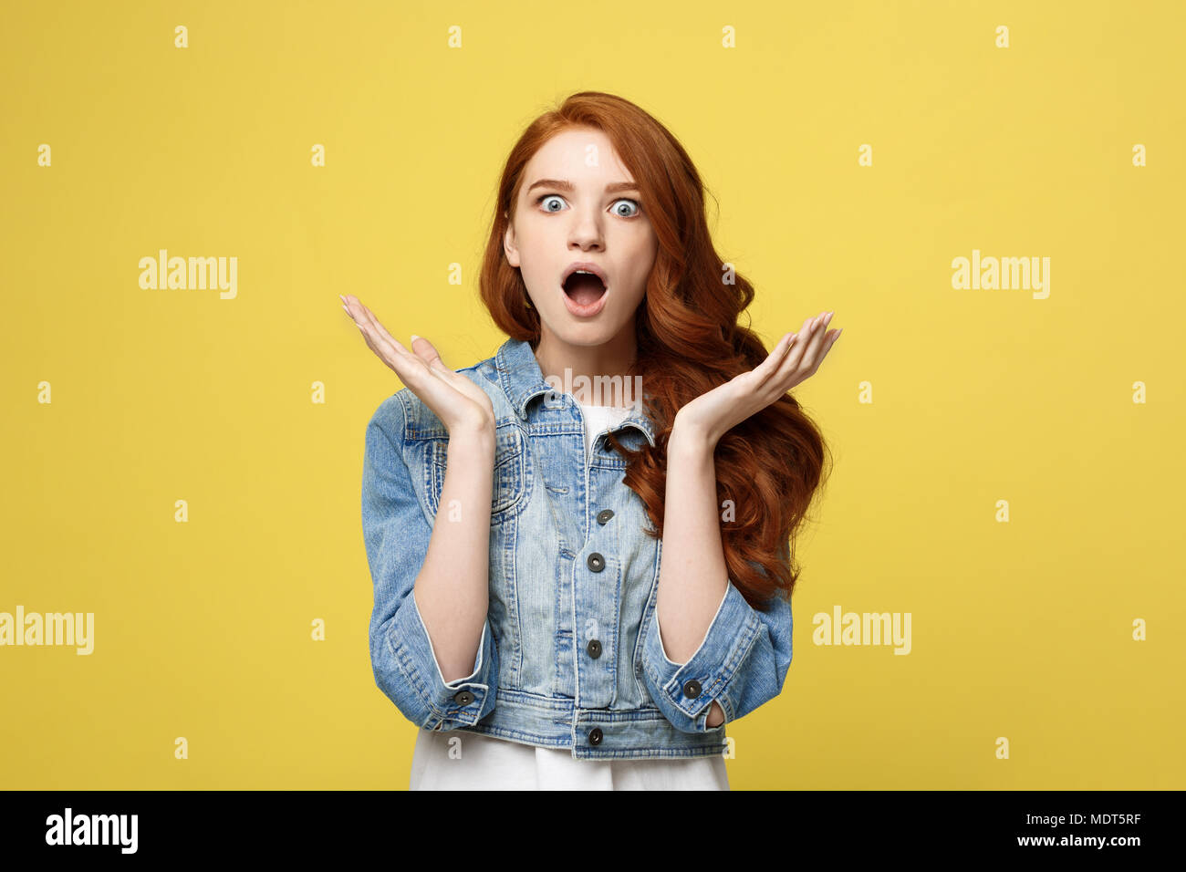 Lifestyle Concept: Surprised young woman with hand on side over golden ...