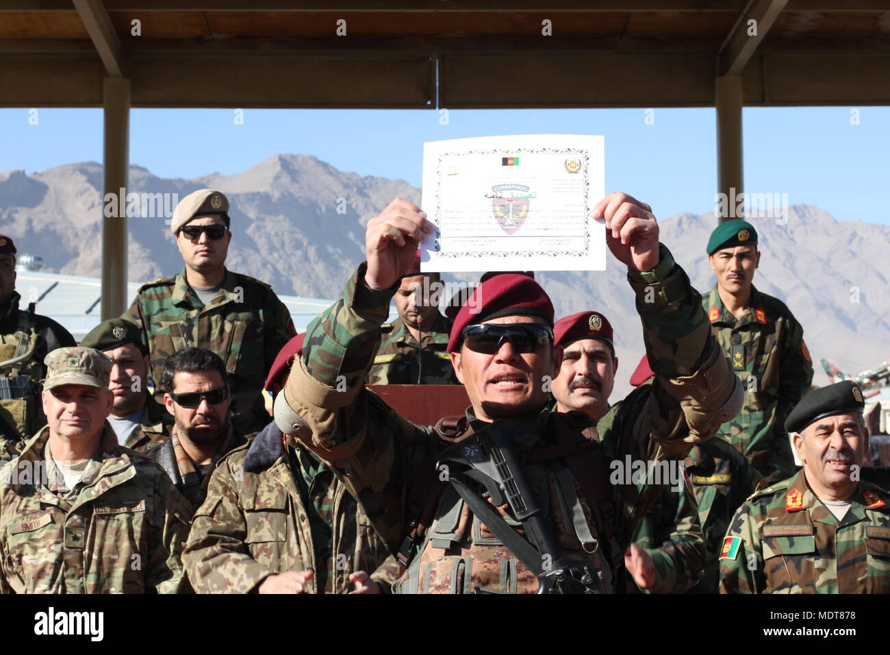 An Afghan Commando presents his course certificate to his fellow ...