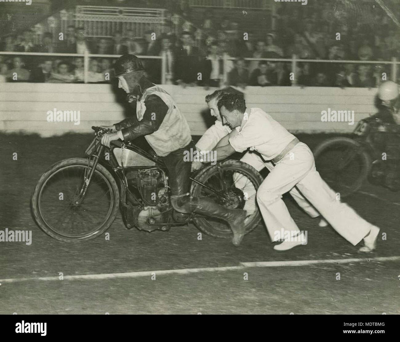 Motor bike racer getting a push start at the track,. Location: Brisbane ...