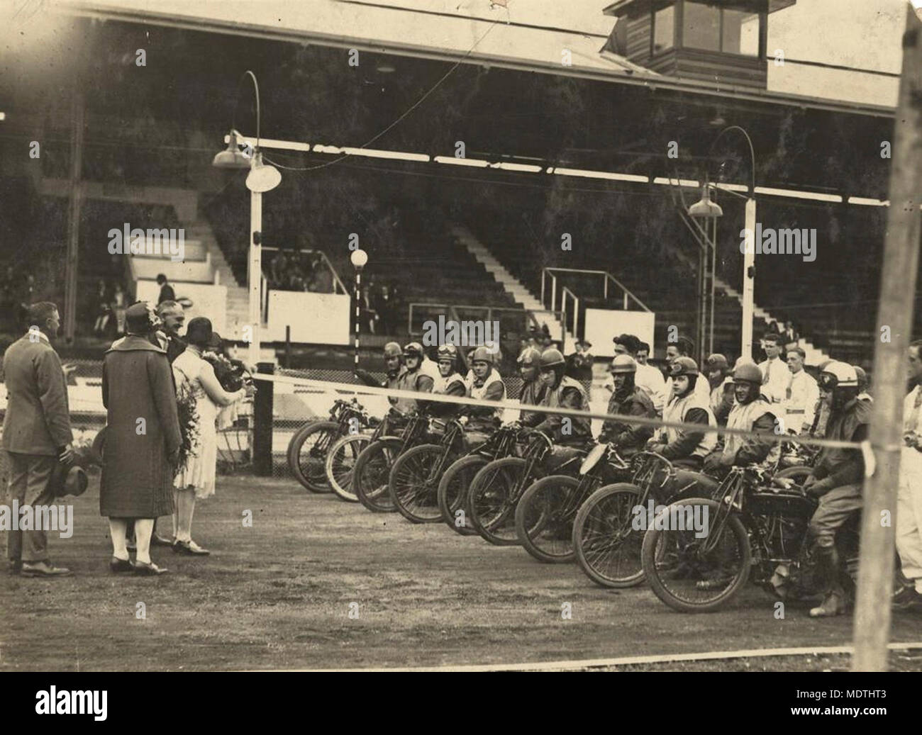 Officials cutting the starting ribbon at a speedway motorcycle race ...