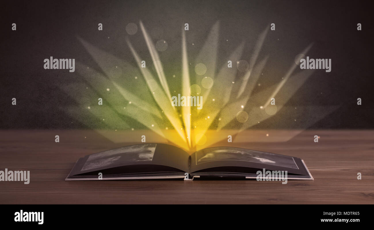 Yellow lights spreading from an open book Stock Photo - Alamy