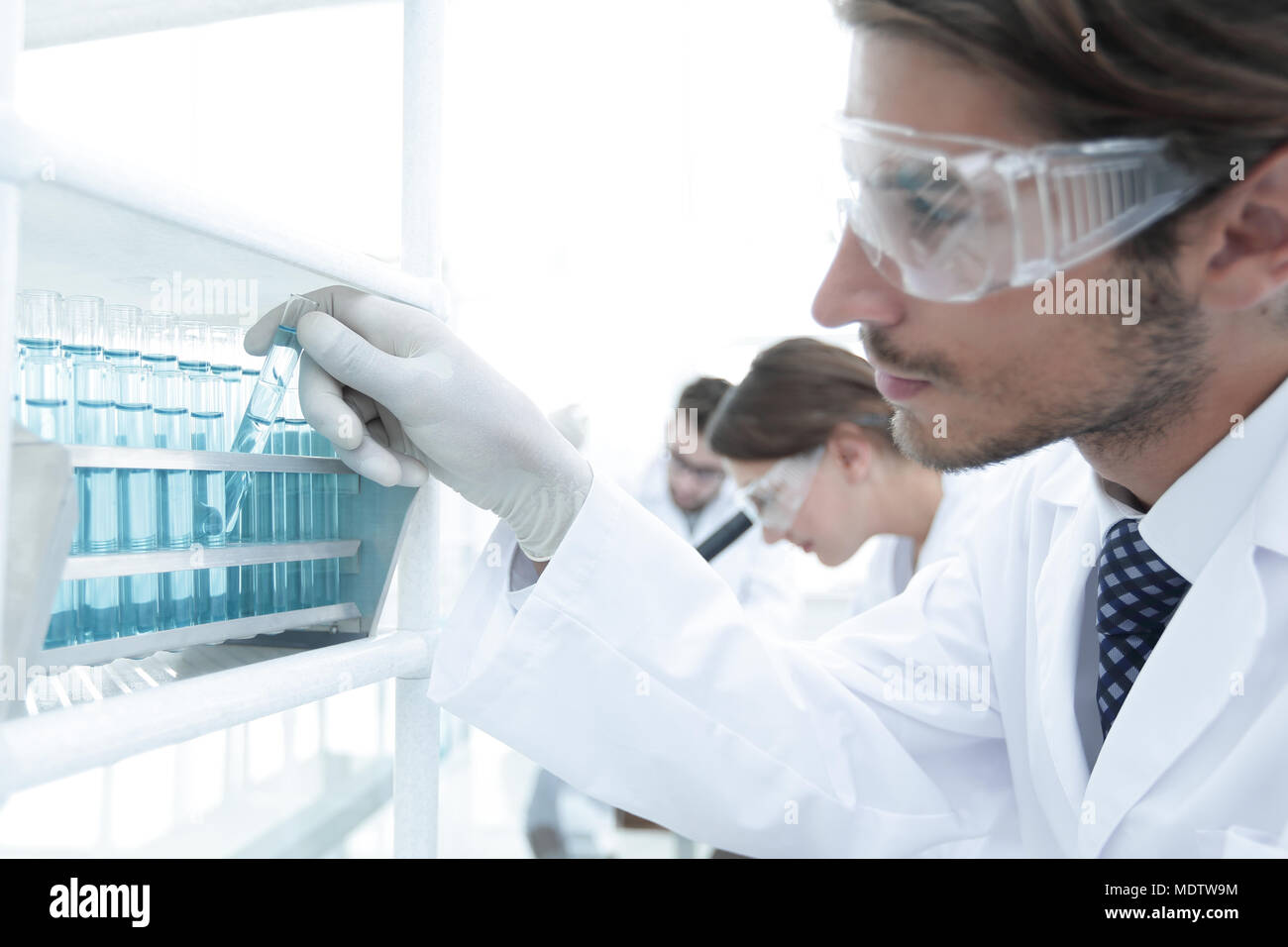 side view of focused scientist holding test tube in laboratory Stock ...