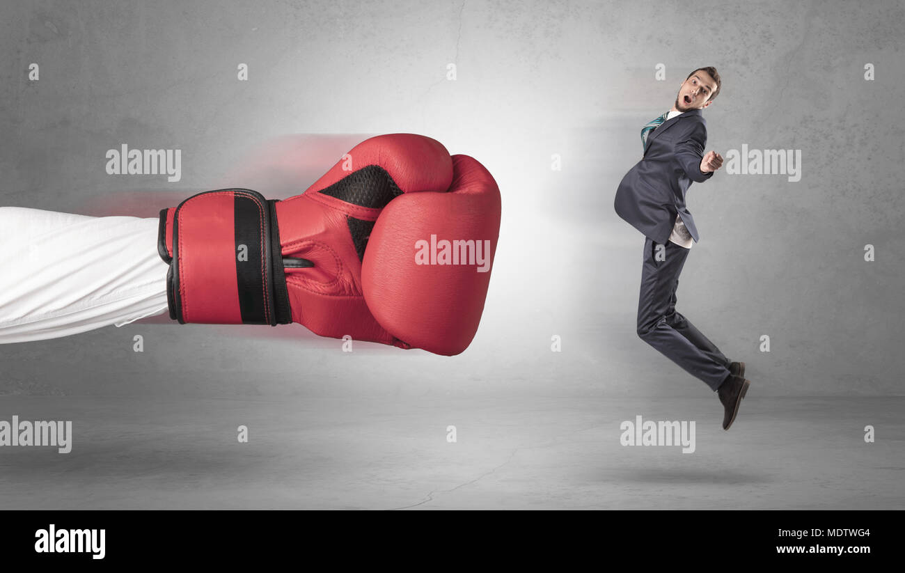 Businessman gets a hit from a giant hand with boxing gloves Stock Photo ...