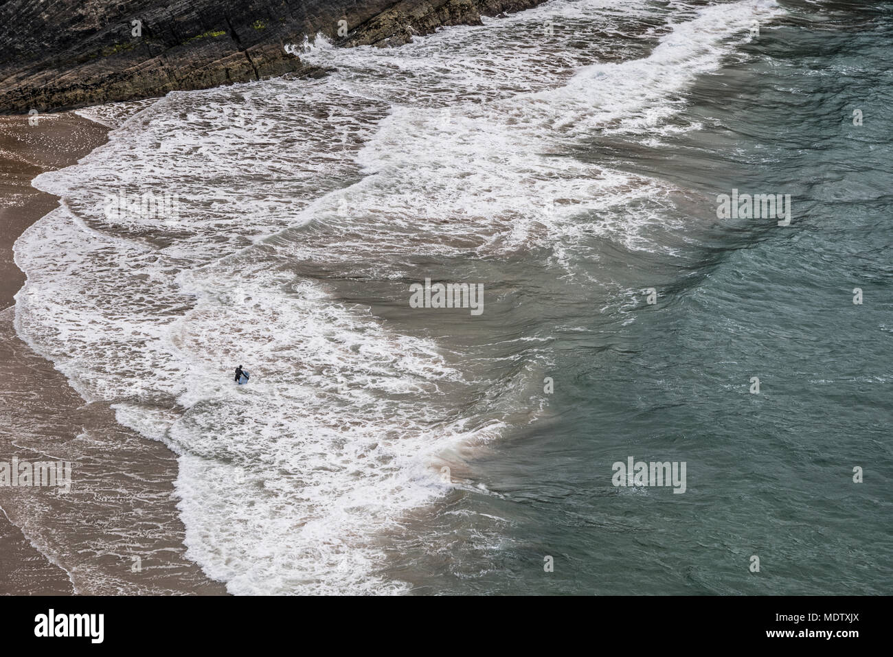 Surfer heading into the waves at Mwnt Beach Stock Photo - Alamy