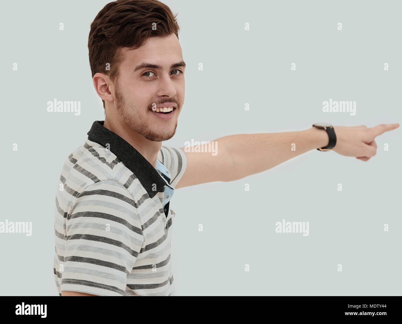 side view.modern young man pointing forward and looking at the camera ...