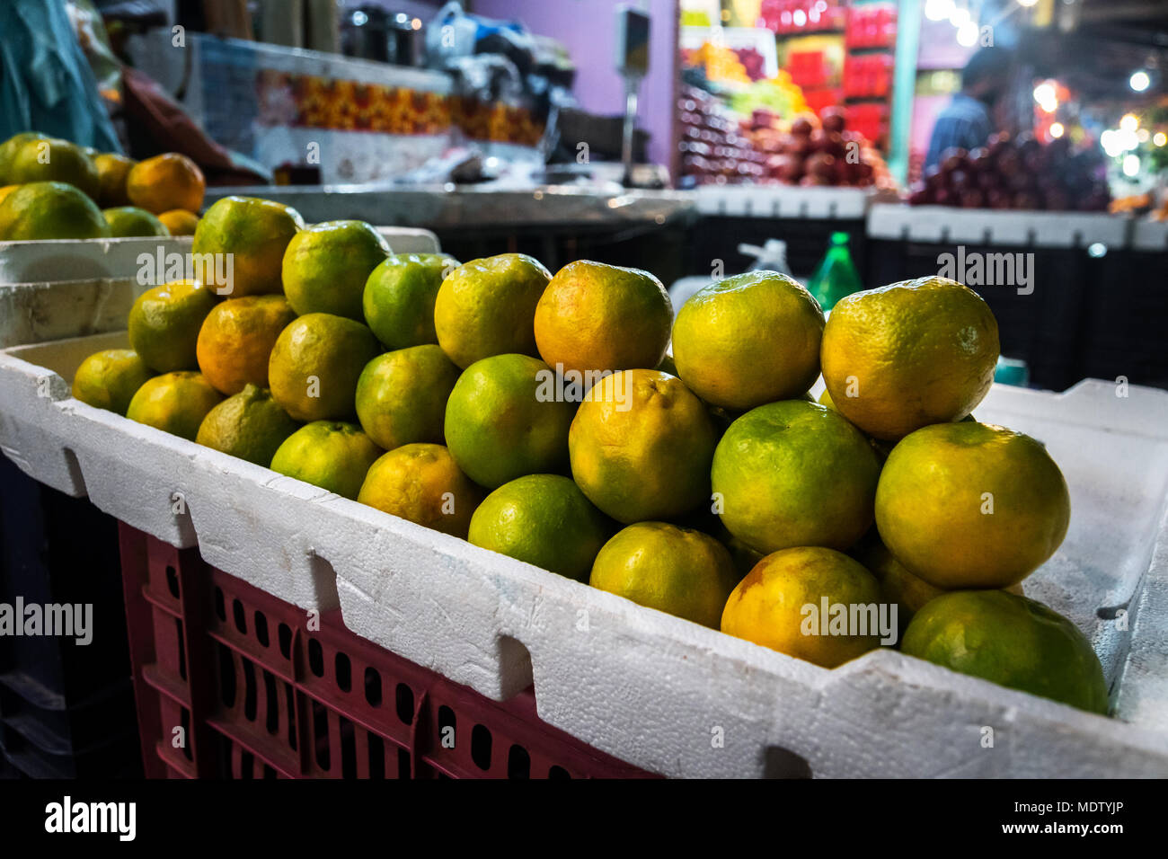 a bunch of ripe orange oranges on the counter in a street shop in India ...