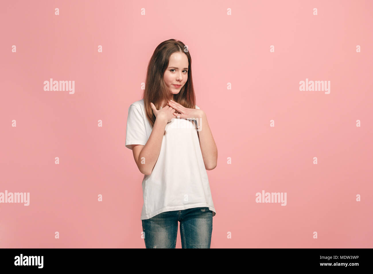 The happy teen girl standing and smiling against pink background Stock ...