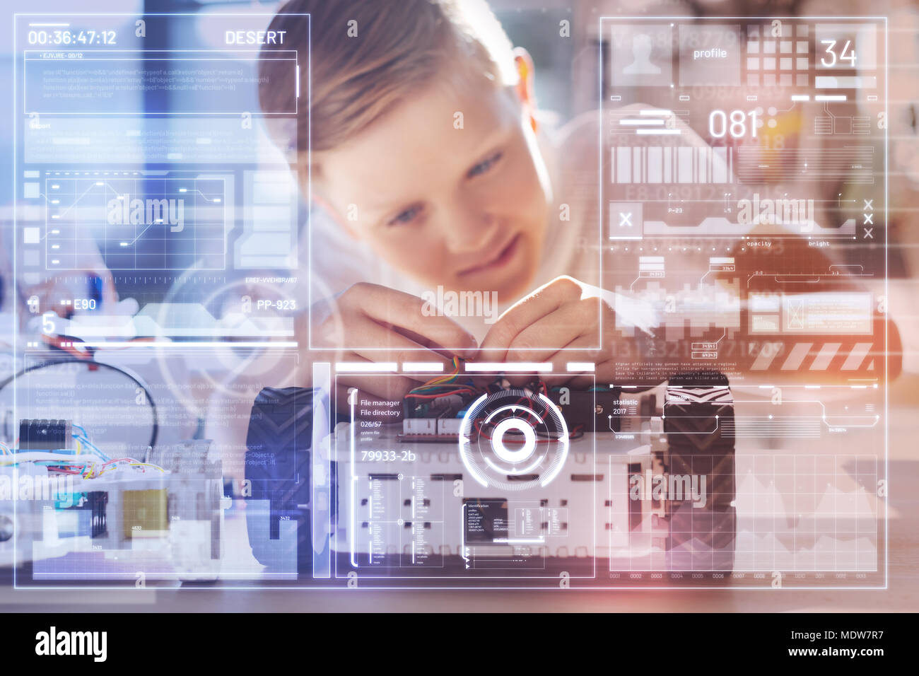 Concentrated child looking busy while making a robot Stock Photo - Alamy