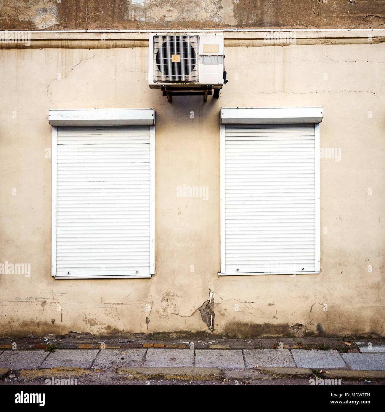 Old yellow wall with two windows and air conditioner Stock Photo - Alamy