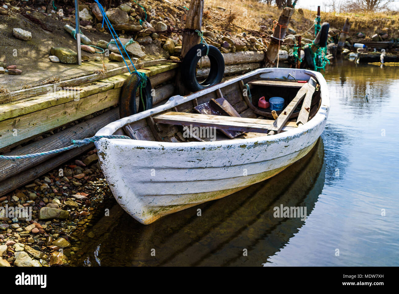White rowboat tied to a pier on a sunny day Stock Photo - Alamy