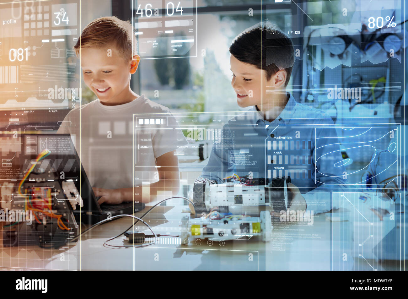 Cheerful classmates smiling while working at their unusual project ...