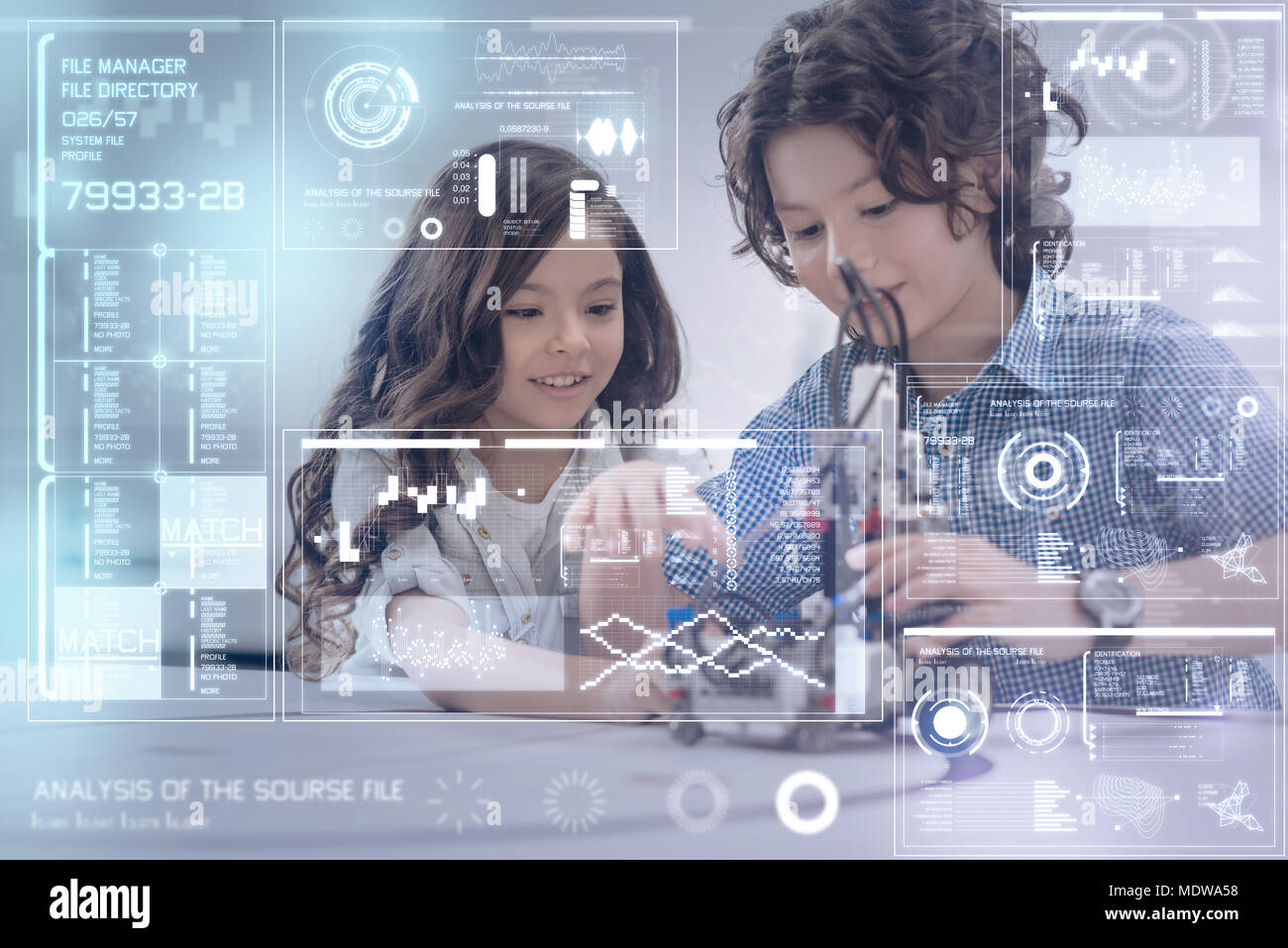 Cheerful smart children smiling while constructing together Stock Photo ...