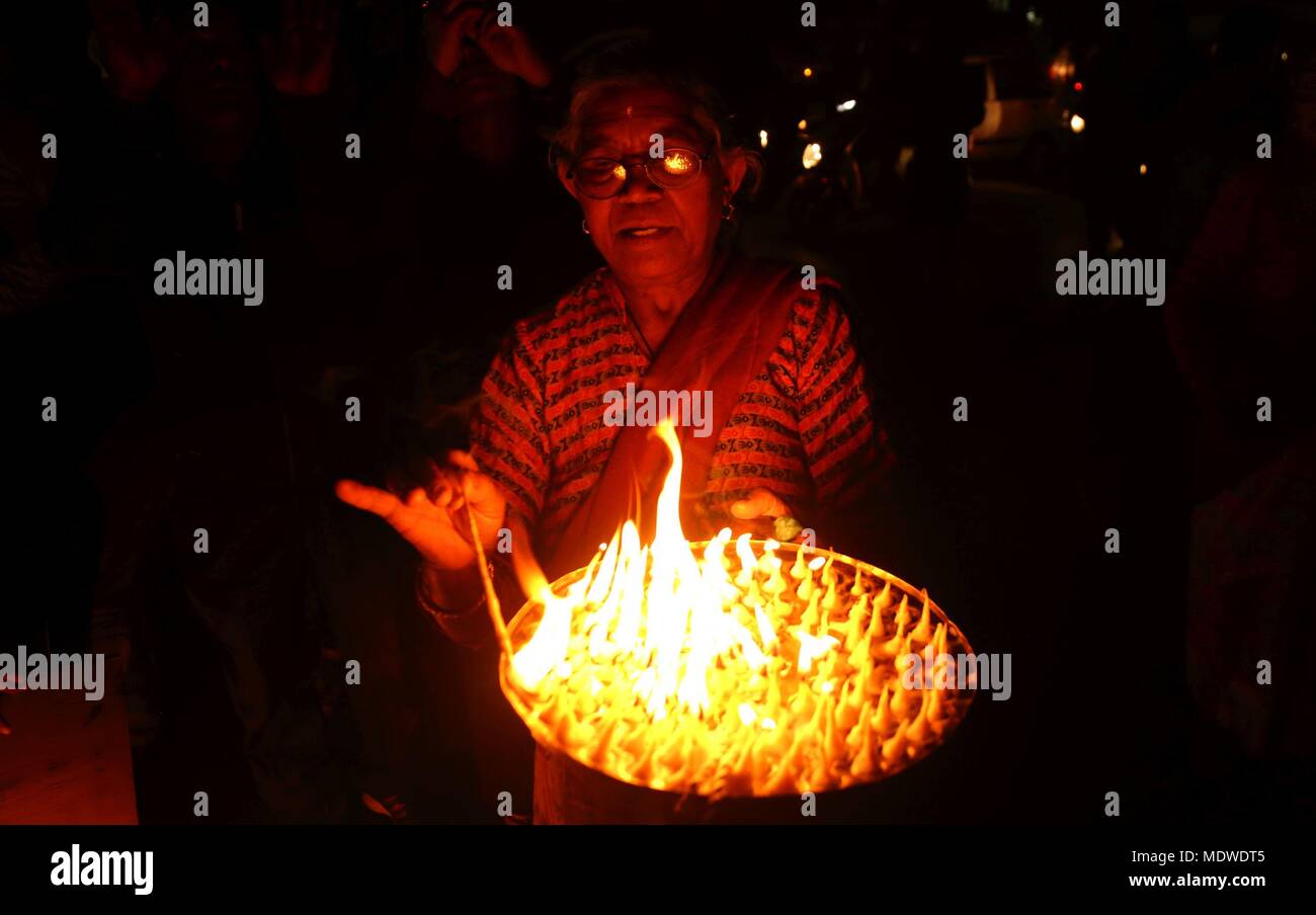 Lalitpur, Nepal. 19th Apr, 2018. A devotee offers prayers by lighting ...