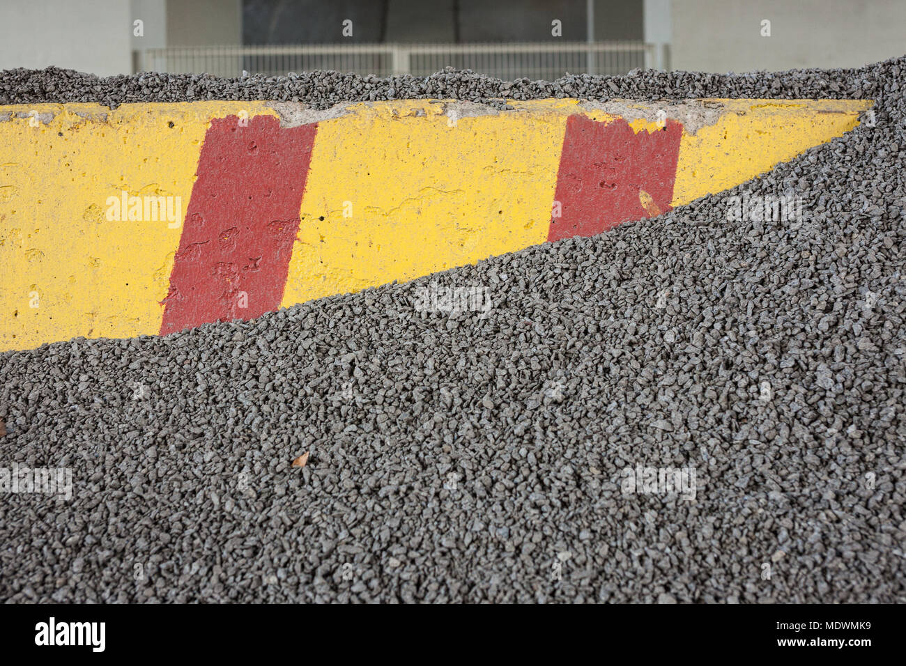 Worn concrete roadblock in gravel Stock Photo - Alamy