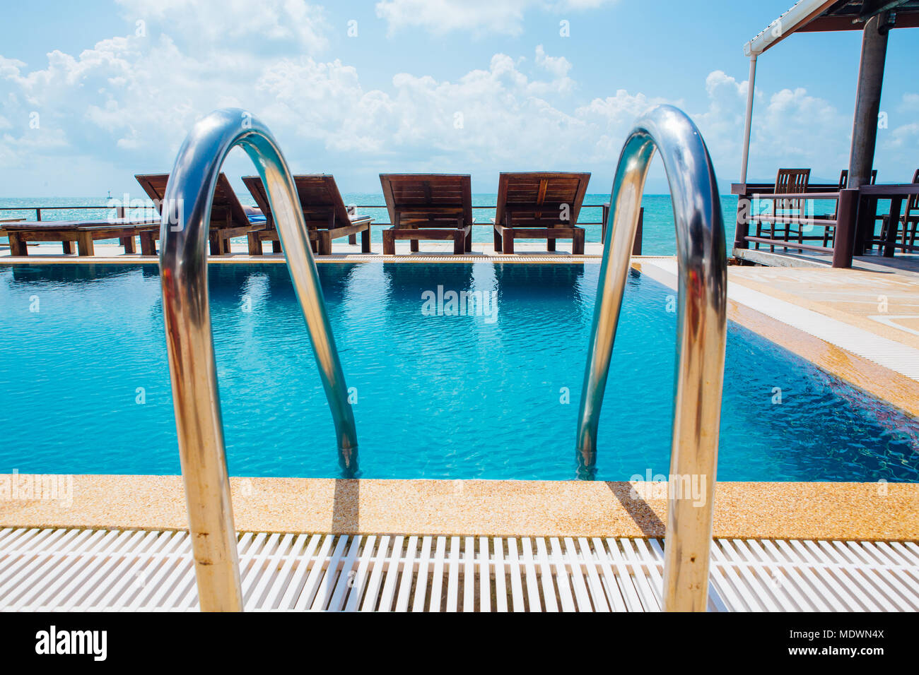Swimming pool with stair and stone deck at hotel. Sea view Stock Photo ...