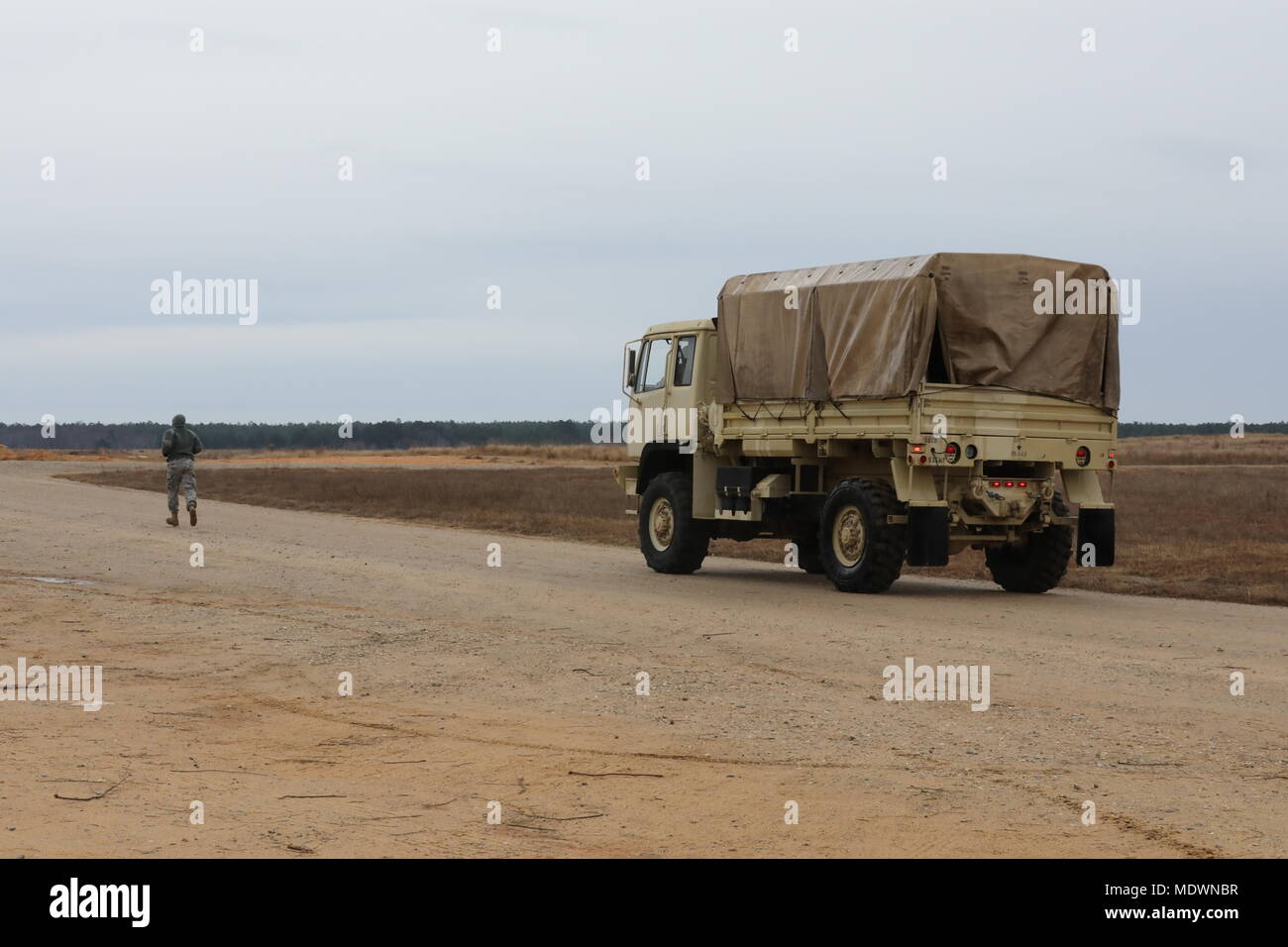 A U.S. Army Soldier ground-guides a light medium tactical vehicle from ...