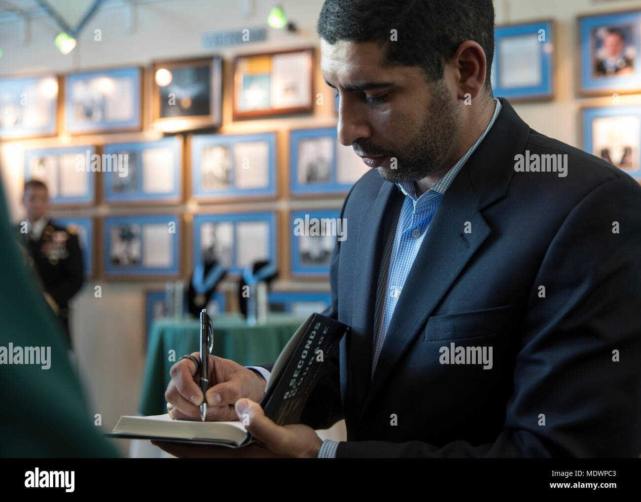 Capt. (R) Florent Groberg, Medal of Honor recipient, autographs a copy ...