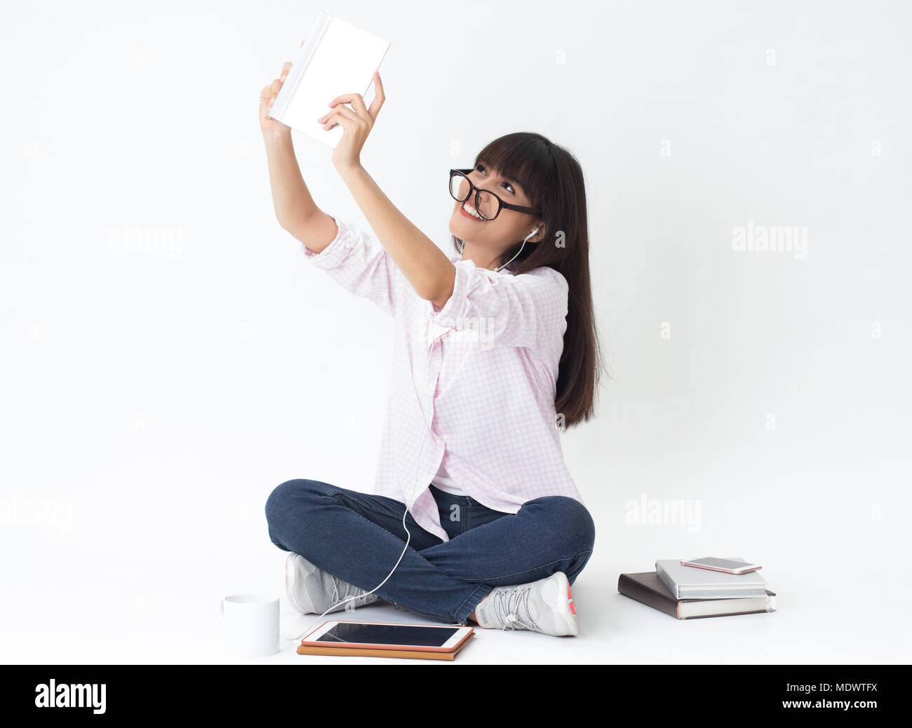 Beautiful girl learning and study hard sitting on white background ...