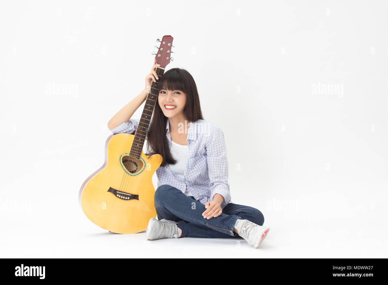 Beautiful asian girl learn to play music online sitting on white ...