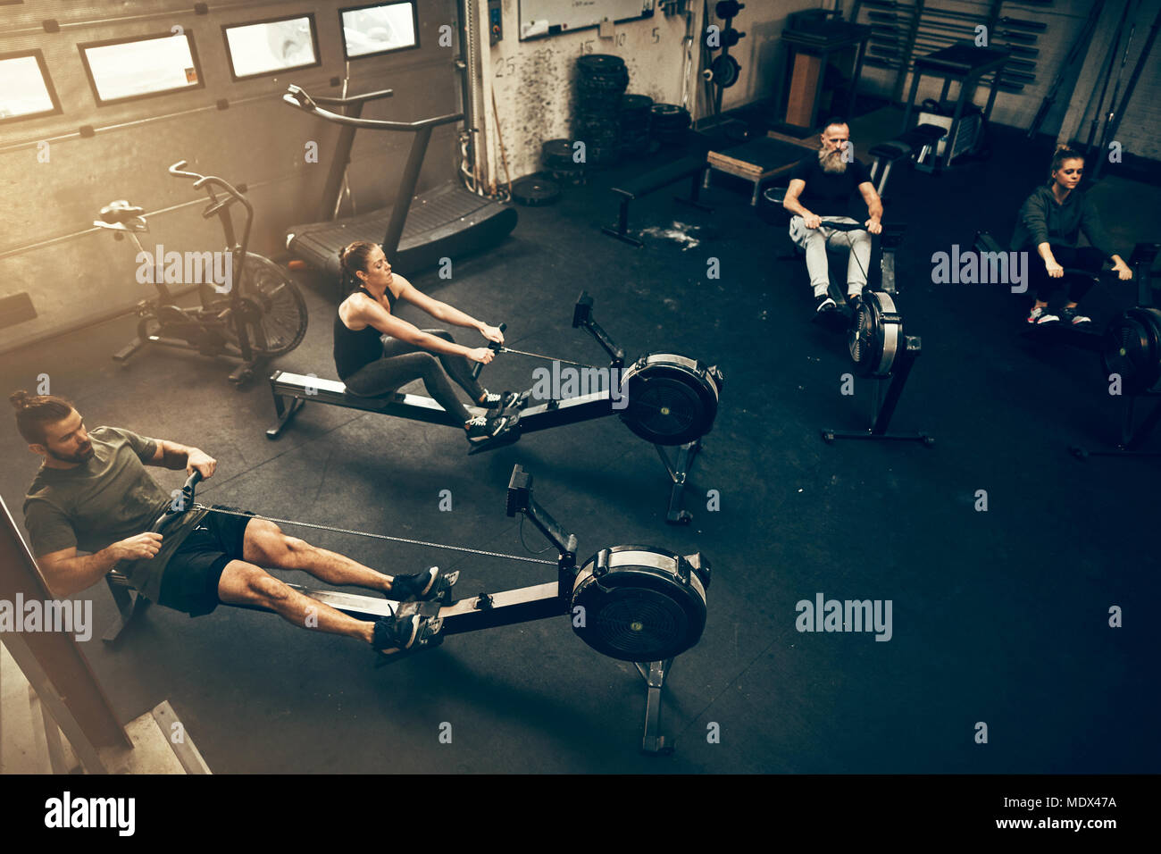 High angle of a group of people working out on rowing machines during ...