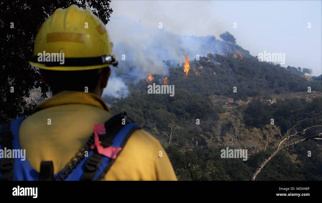 A Kern County firefighter stands watch as the Thomas Fire starts to ...