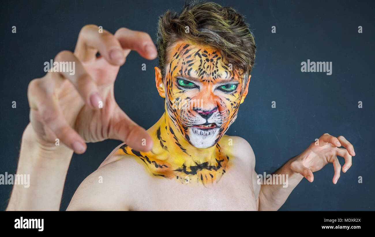 man with a tiger face art on a dark background Stock Photo - Alamy