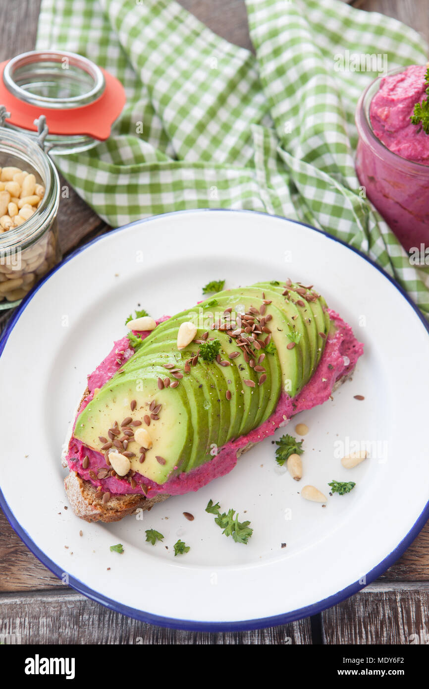 Slice of bread with red beet hummus and fresh avocado Stock Photo - Alamy