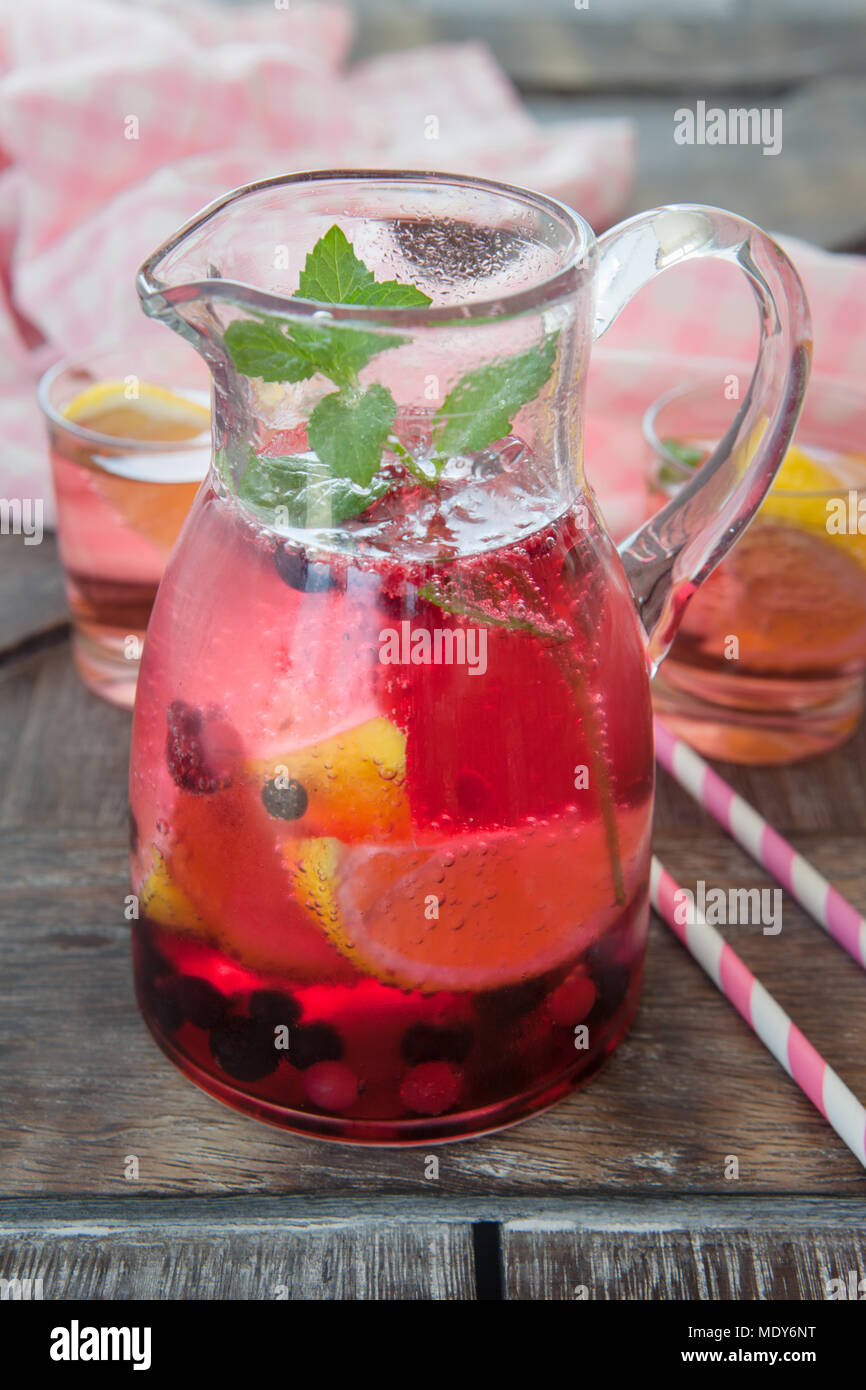 Little pitcher with pink lemonade and fresh fruits Stock Photo - Alamy