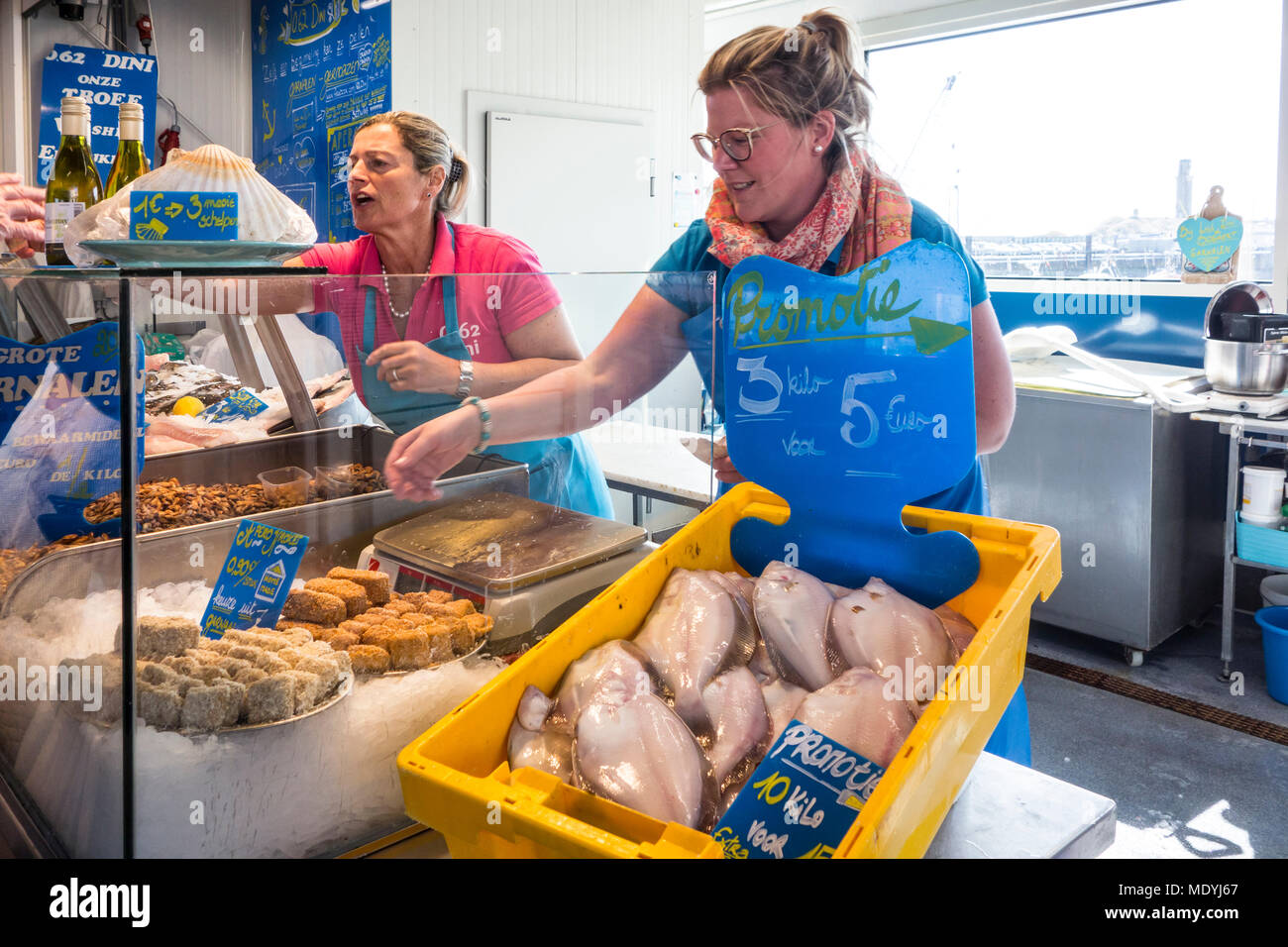 Female fishmongers / vendors selling fresh fish on display at the open ...