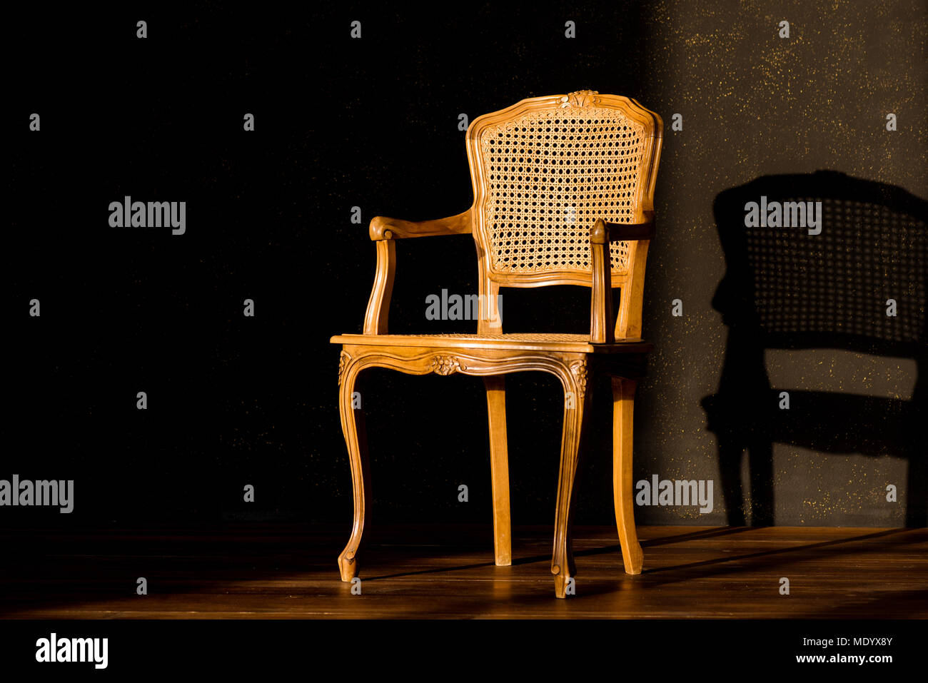 old chair on a black gray wall background Stock Photo - Alamy