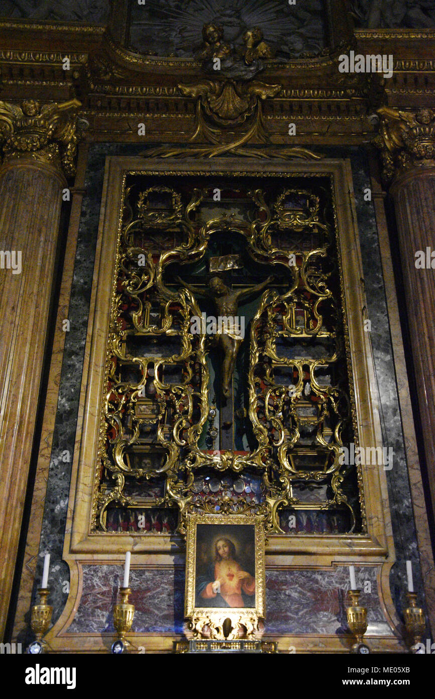 Ornate cross design of the cruxification of Christ above an altar. The ...