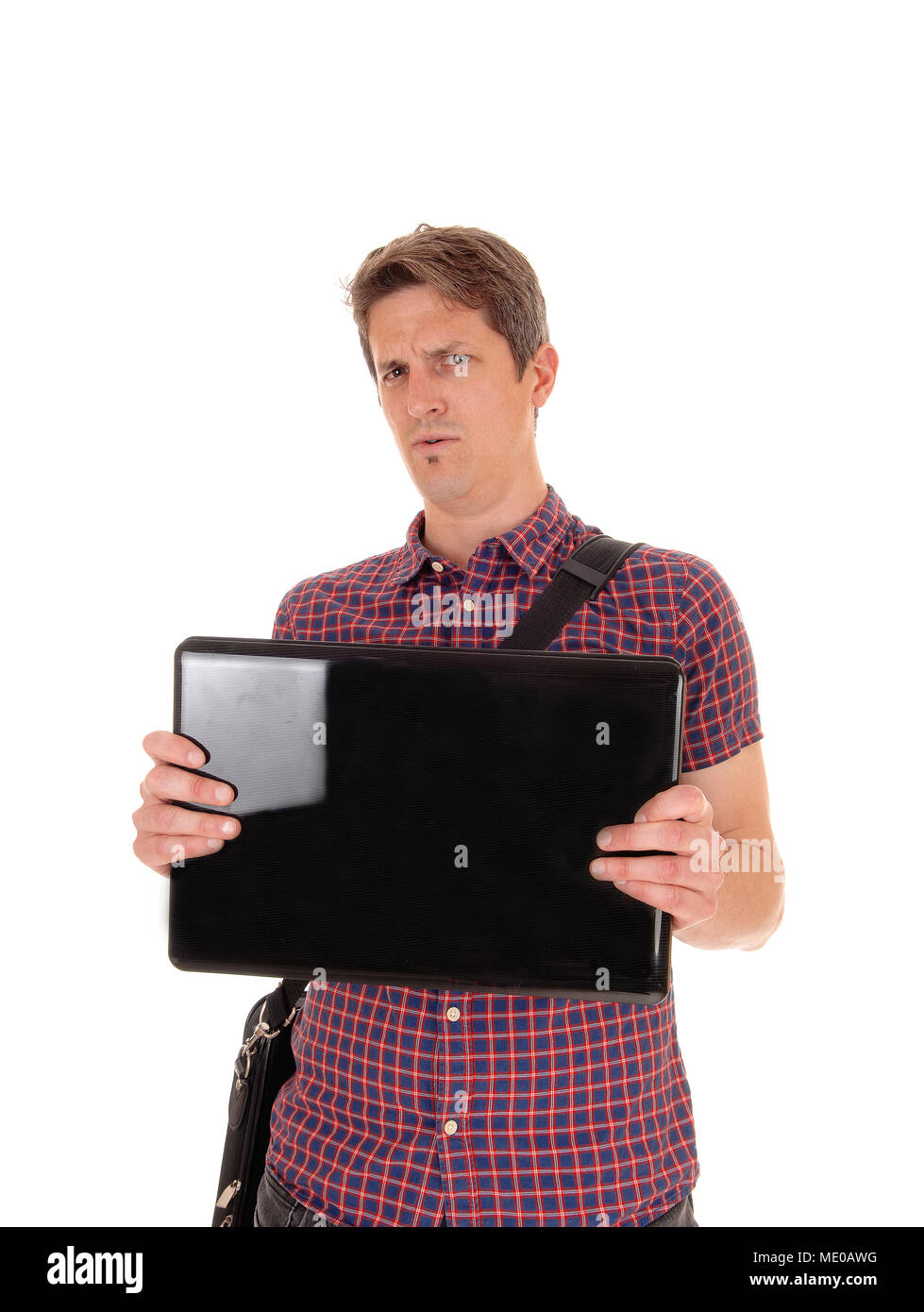 A suspicious man in a checkered shirt holding up his laptop questioning ...