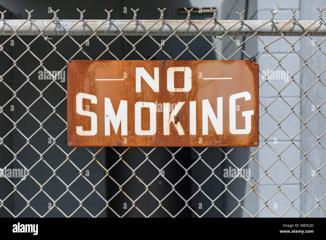 Rusty no smoking sign on a fence Stock Photo - Alamy