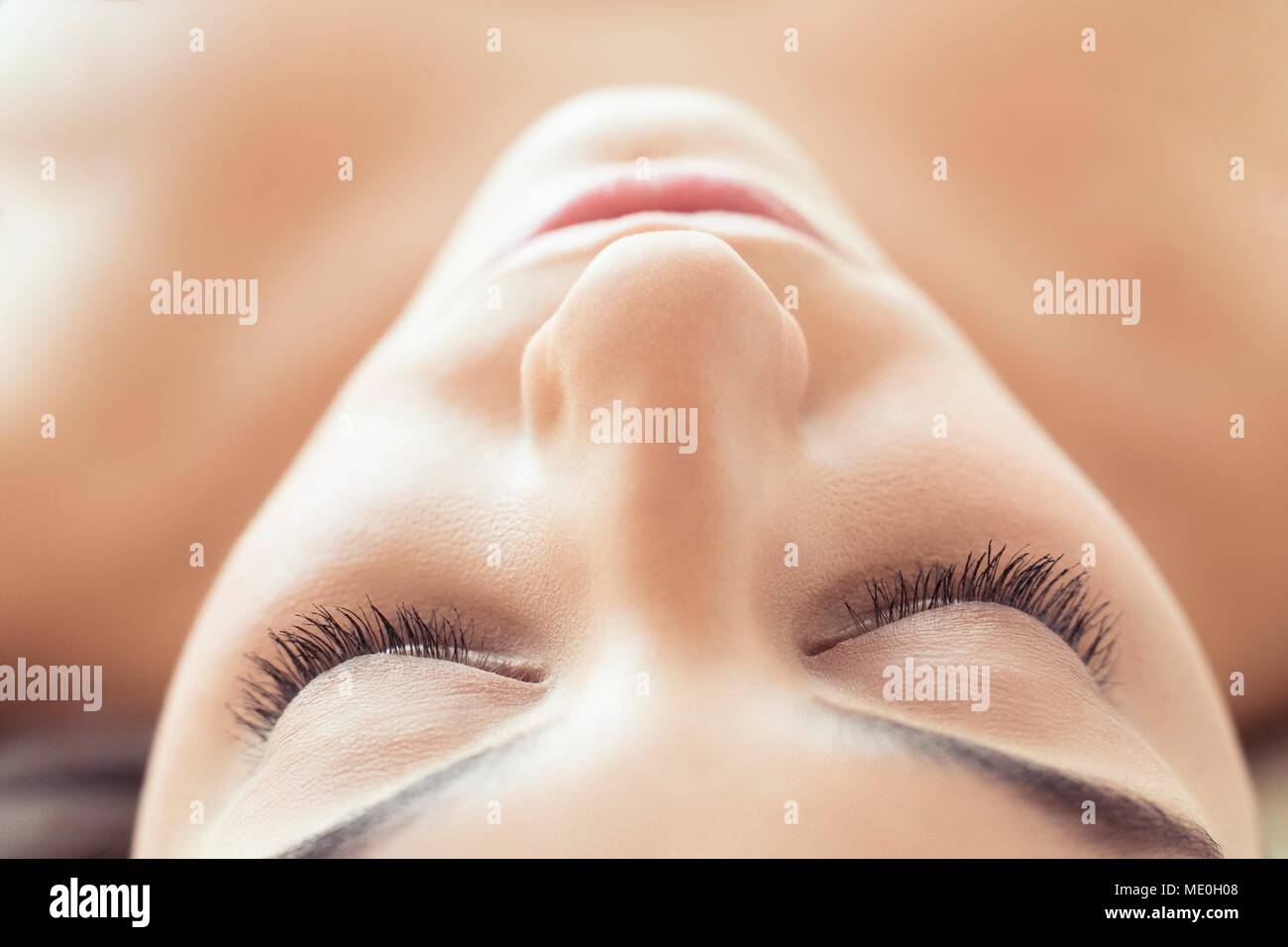 Young woman lying on back with eyes closed Stock Photo - Alamy