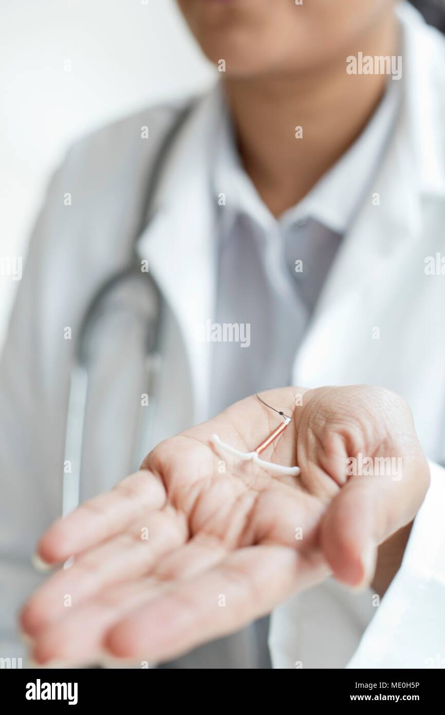 Female doctor holding an IUD (intrauterine device Stock Photo - Alamy