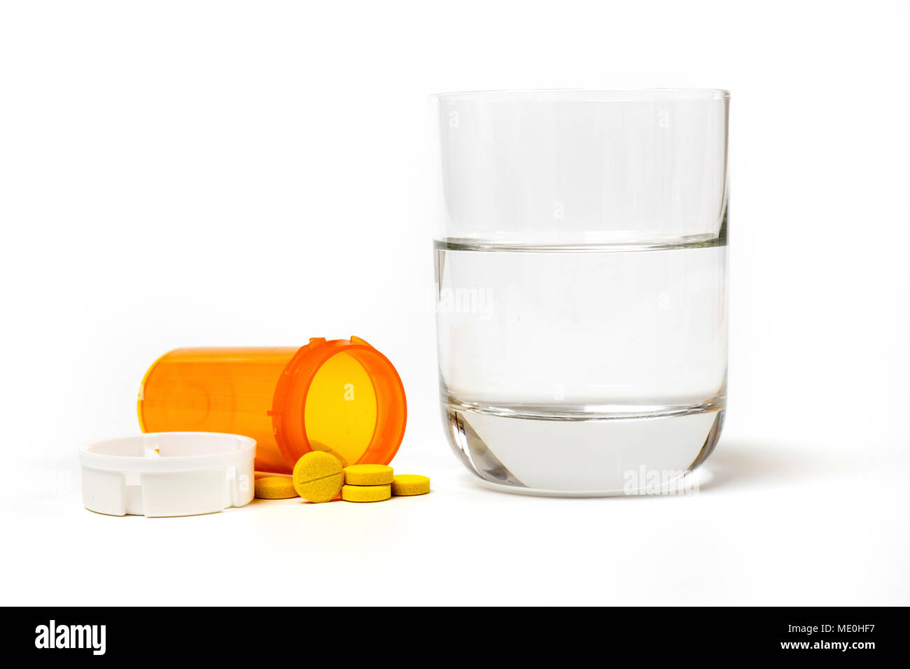Medication and glass of water on a white background Stock Photo - Alamy