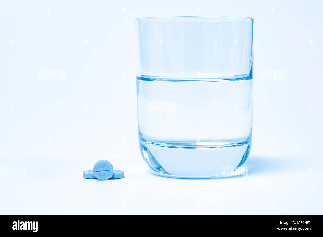 Medication and glass of water on a white background Stock Photo - Alamy