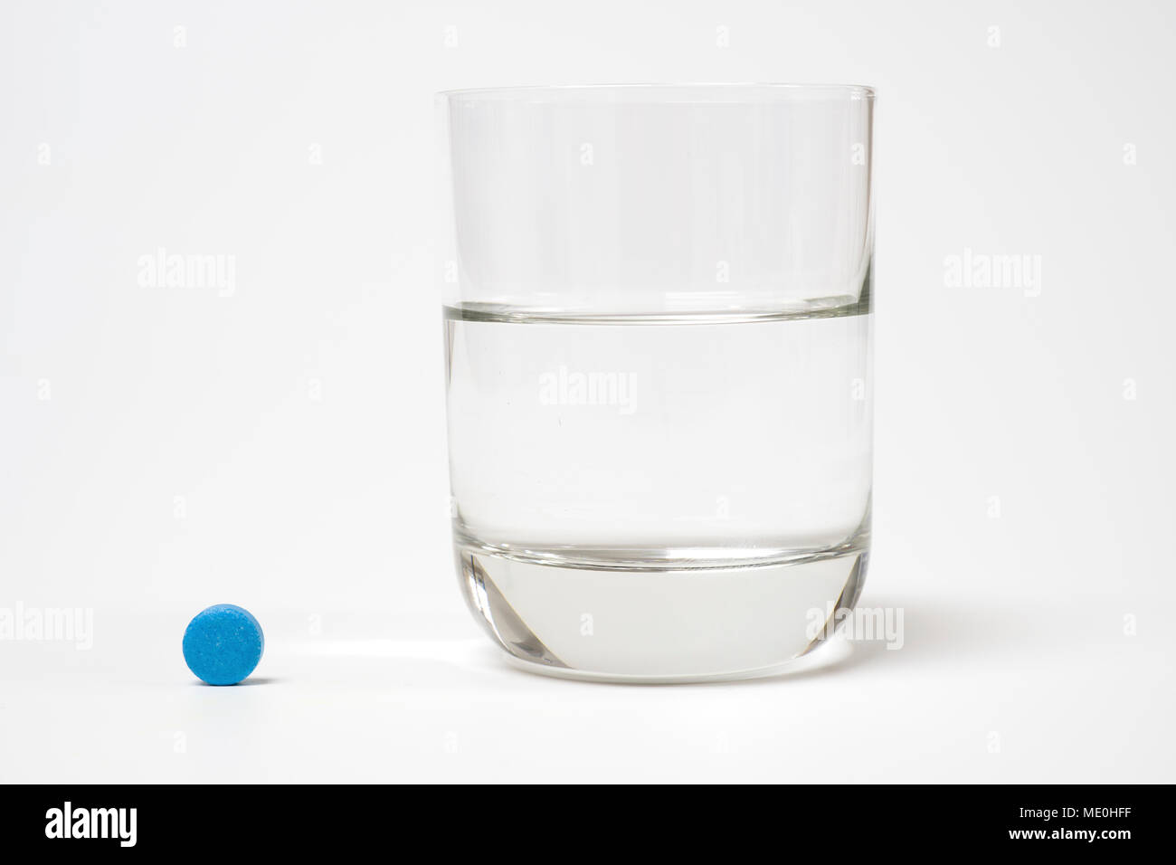 Medication and glass of water on a white background Stock Photo - Alamy