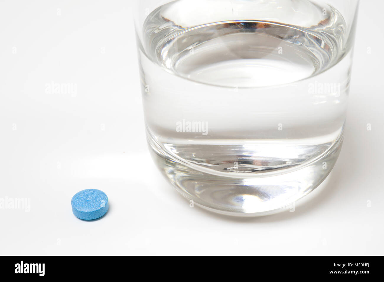 Medication and glass of water on a white background Stock Photo - Alamy